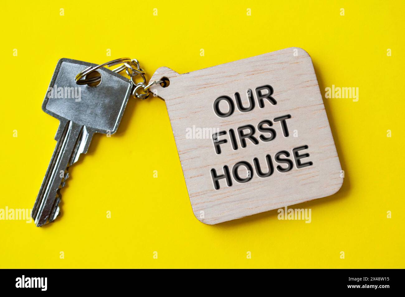 Our first house text engraved on wooden key chain Stock Photo - Alamy