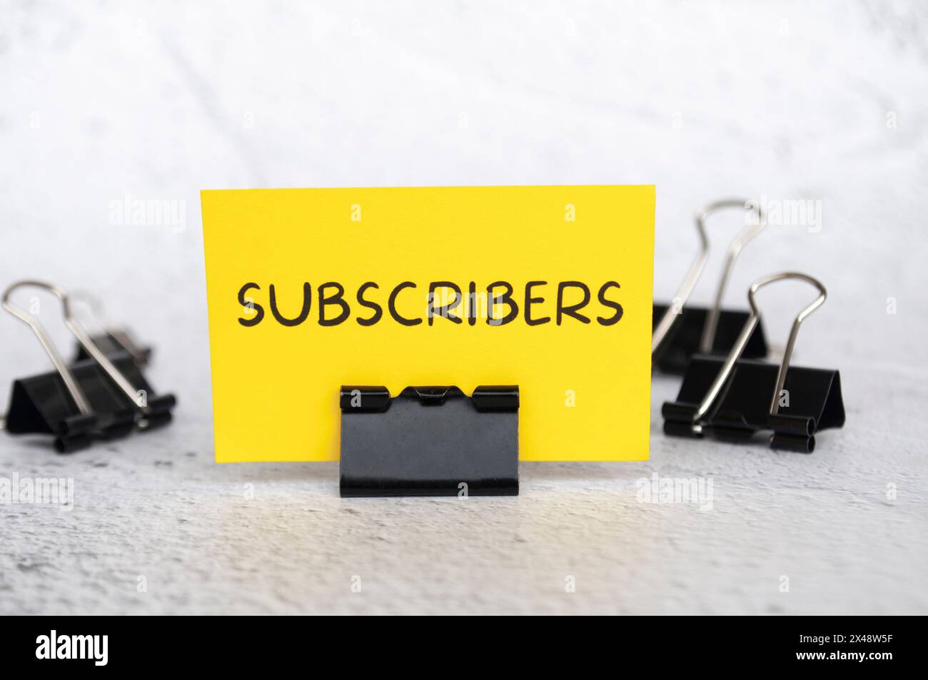 Subscribers text on standing yellow paper Stock Photo - Alamy