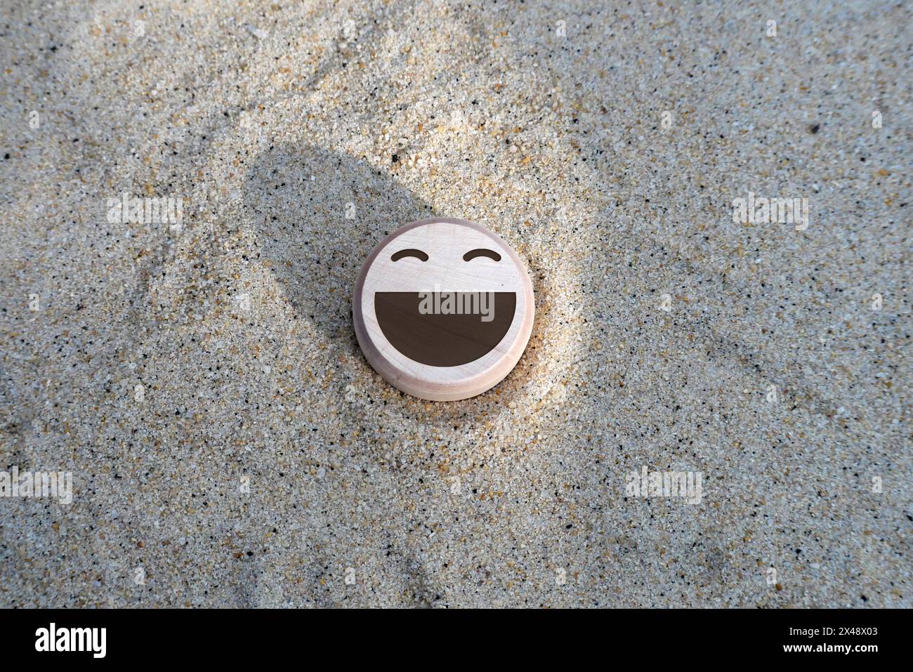 wooden smiley faces on the sand. concept for Service rating ...