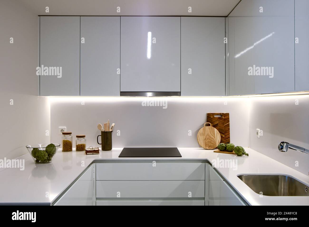 Small modern kitchen with white cabinets, faux stone countertops ...