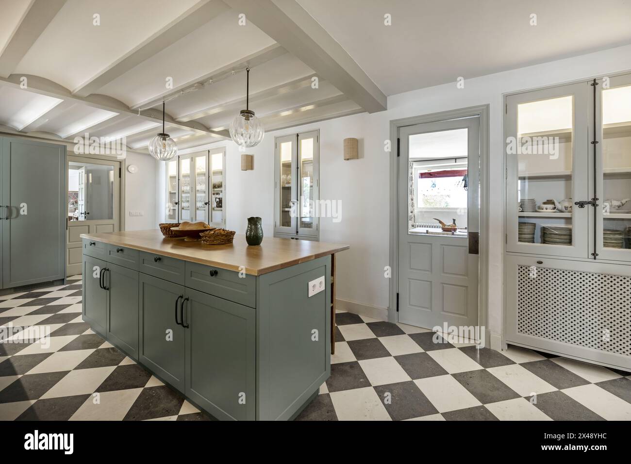 large kitchen with checkerboard floor, built-in cabinets with cupboards ...