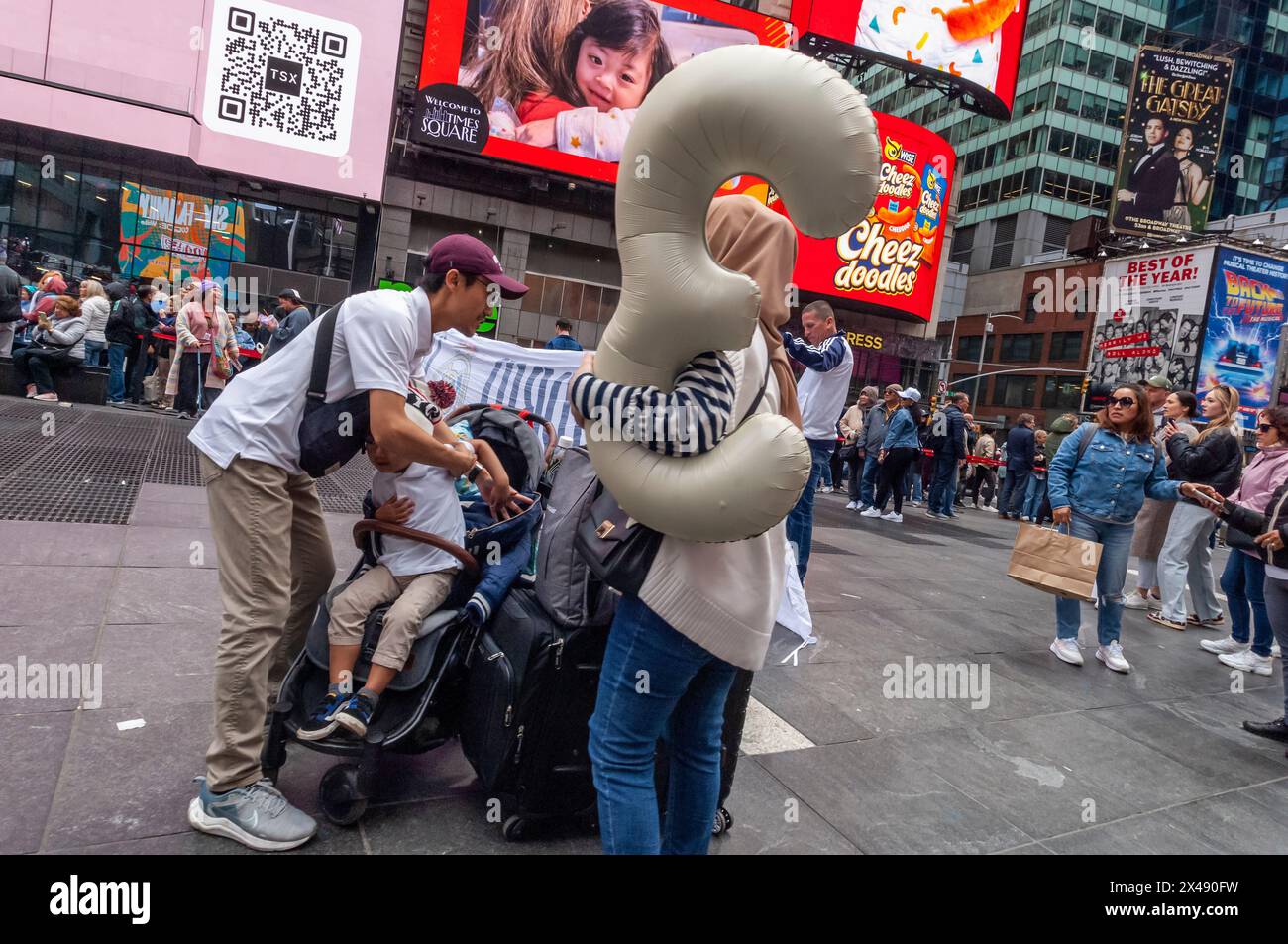 Visitors to Times Square with a balloon celebrating a three-year olds ...