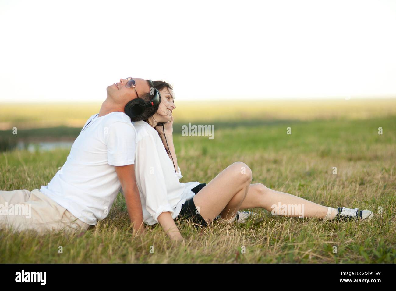 Happy young couple listening to music together Stock Photo - Alamy