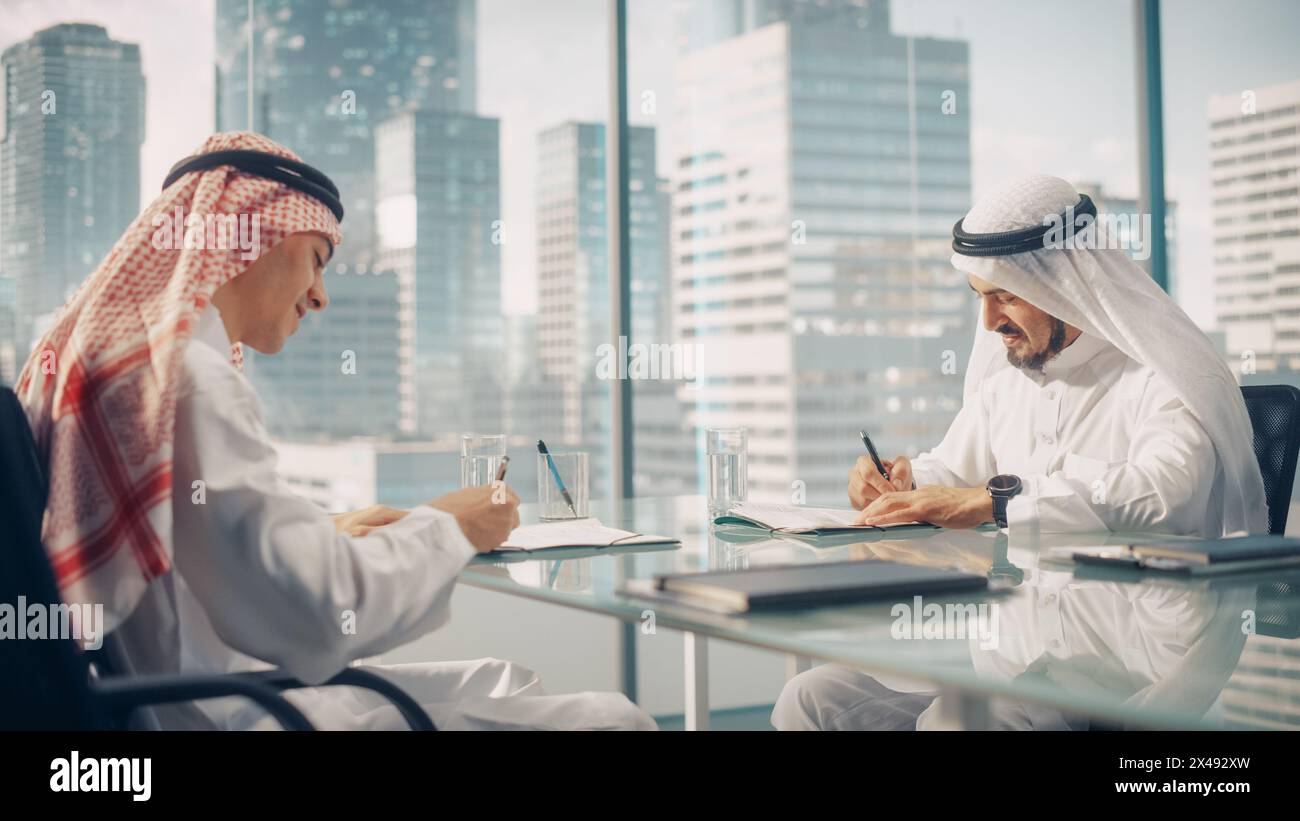Two Happy Emirati Businessmen in White Traditional Kandura Sitting in ...