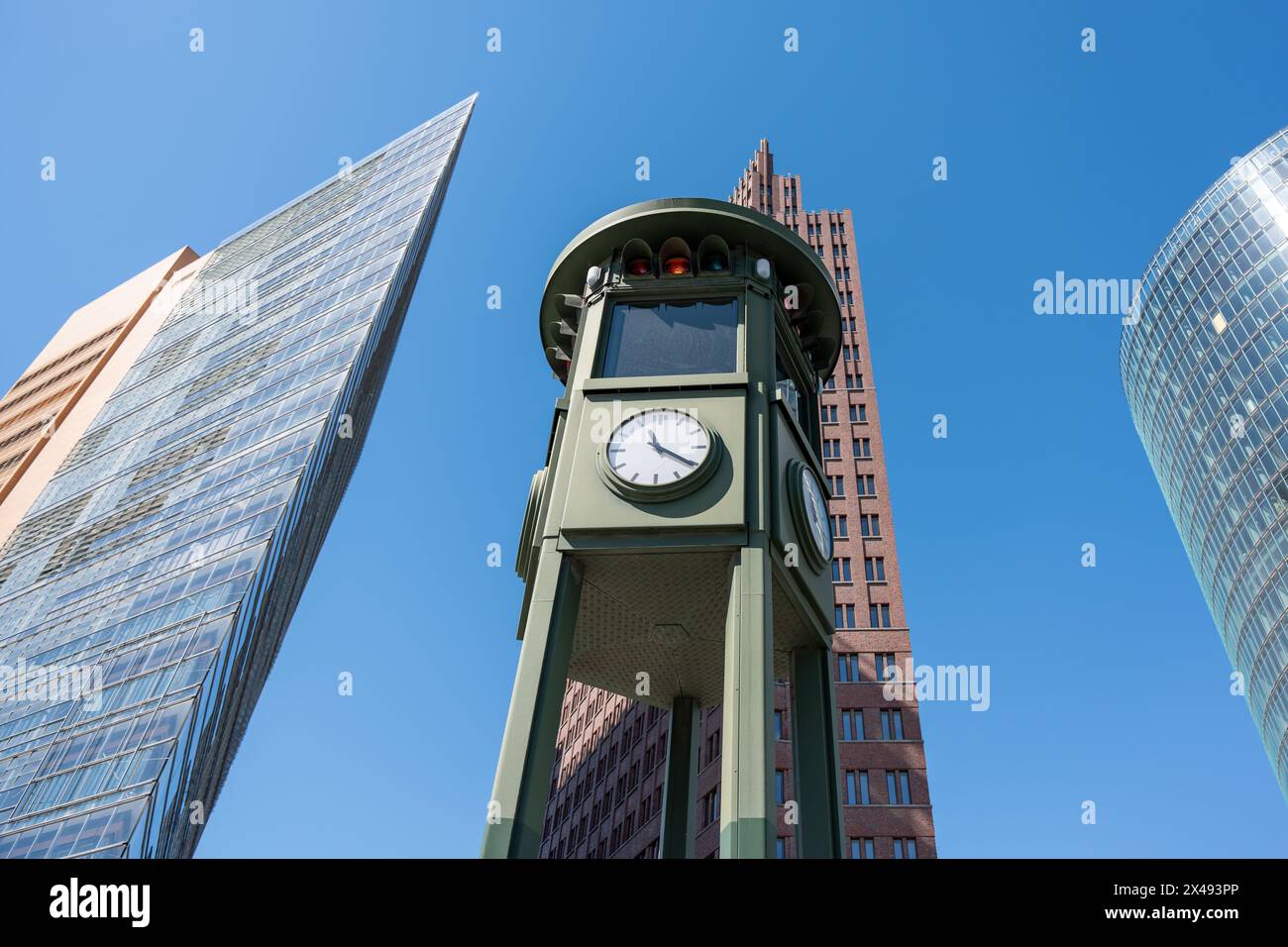 An old tower on which a clock and a traffic light are located against ...