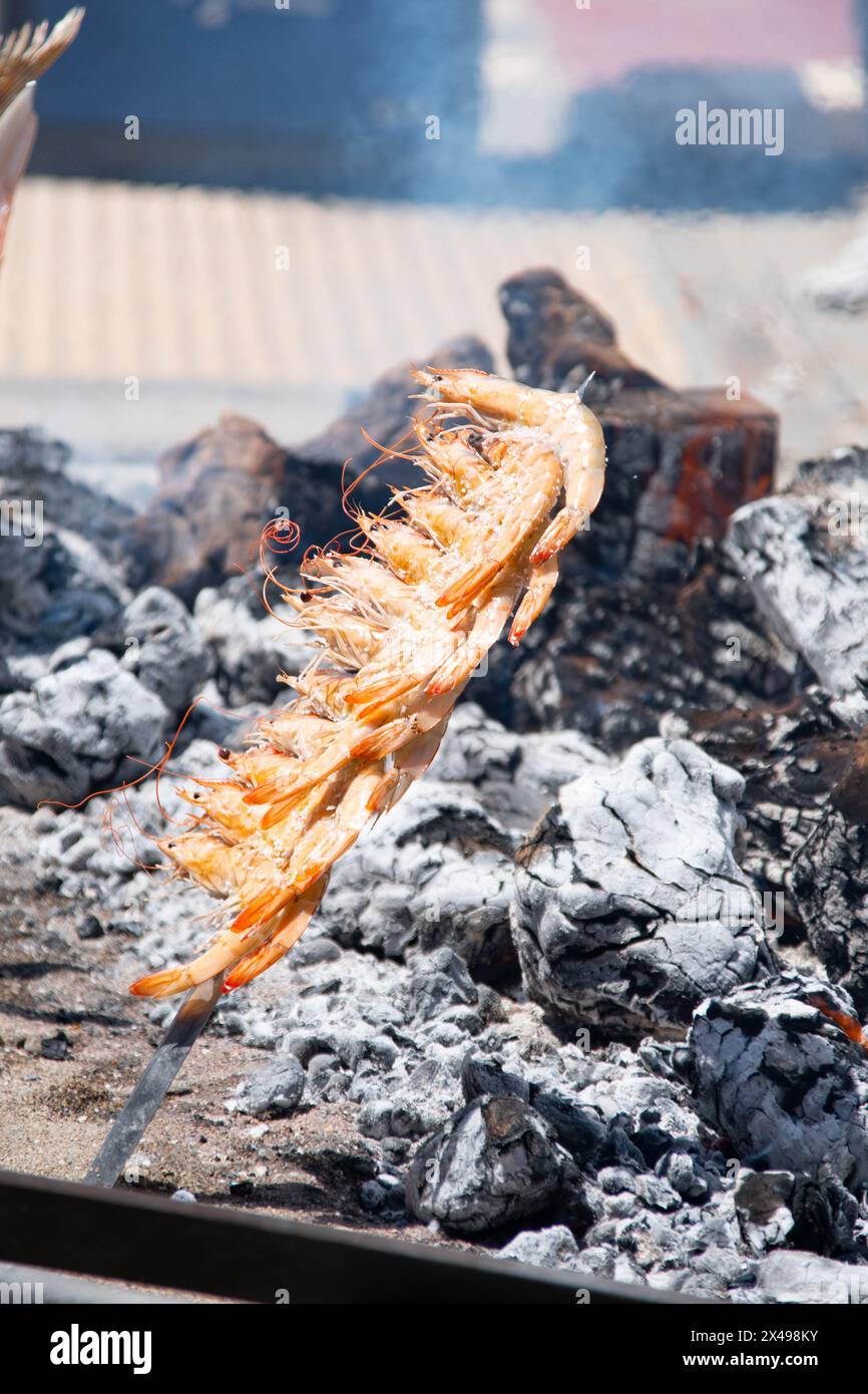 Skewers of octopus, sea bream, shrimp and sardines, grilled over a wood ...