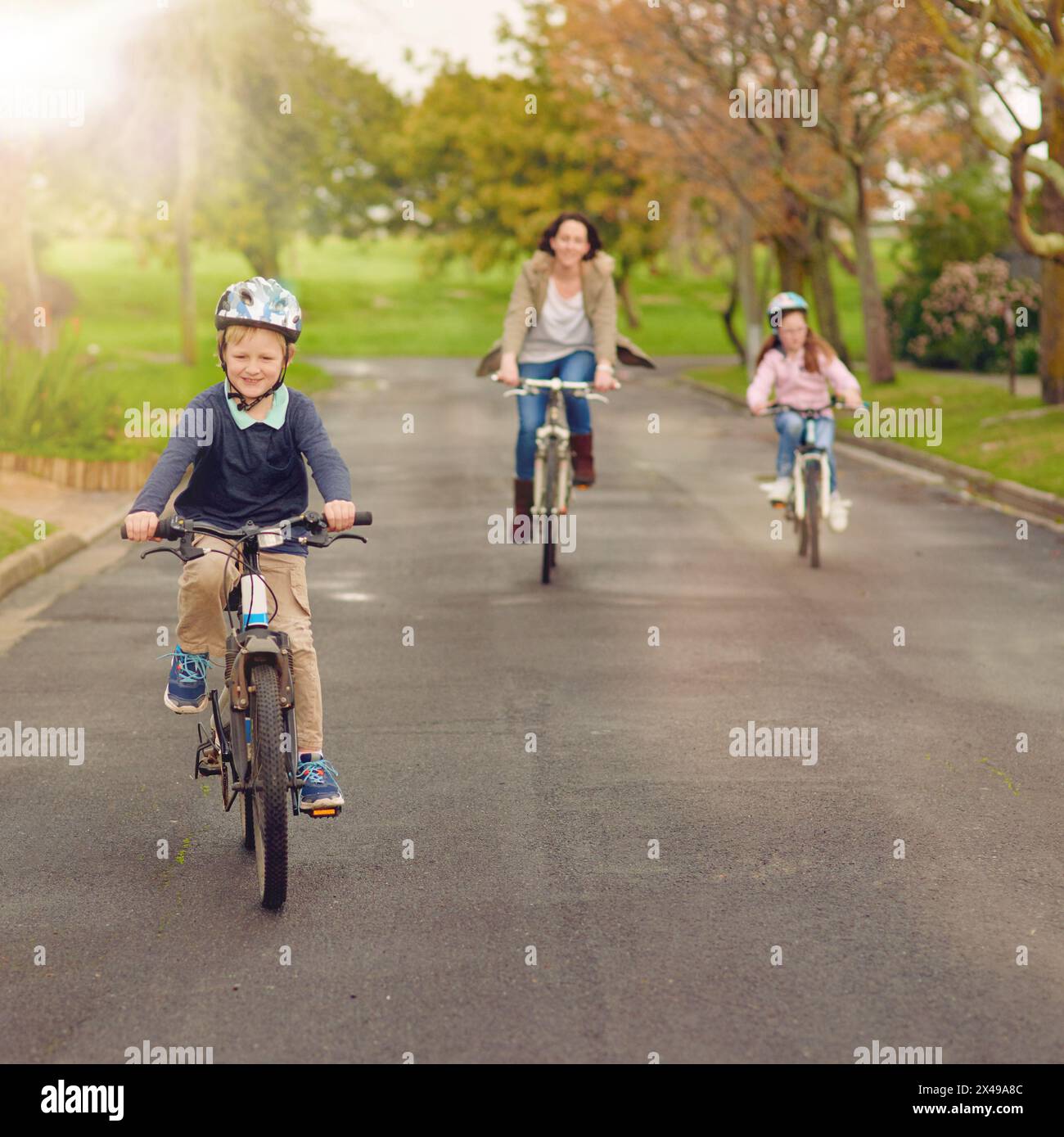 Boy, family and bicycle for fun outside, road and mother with sister in ...