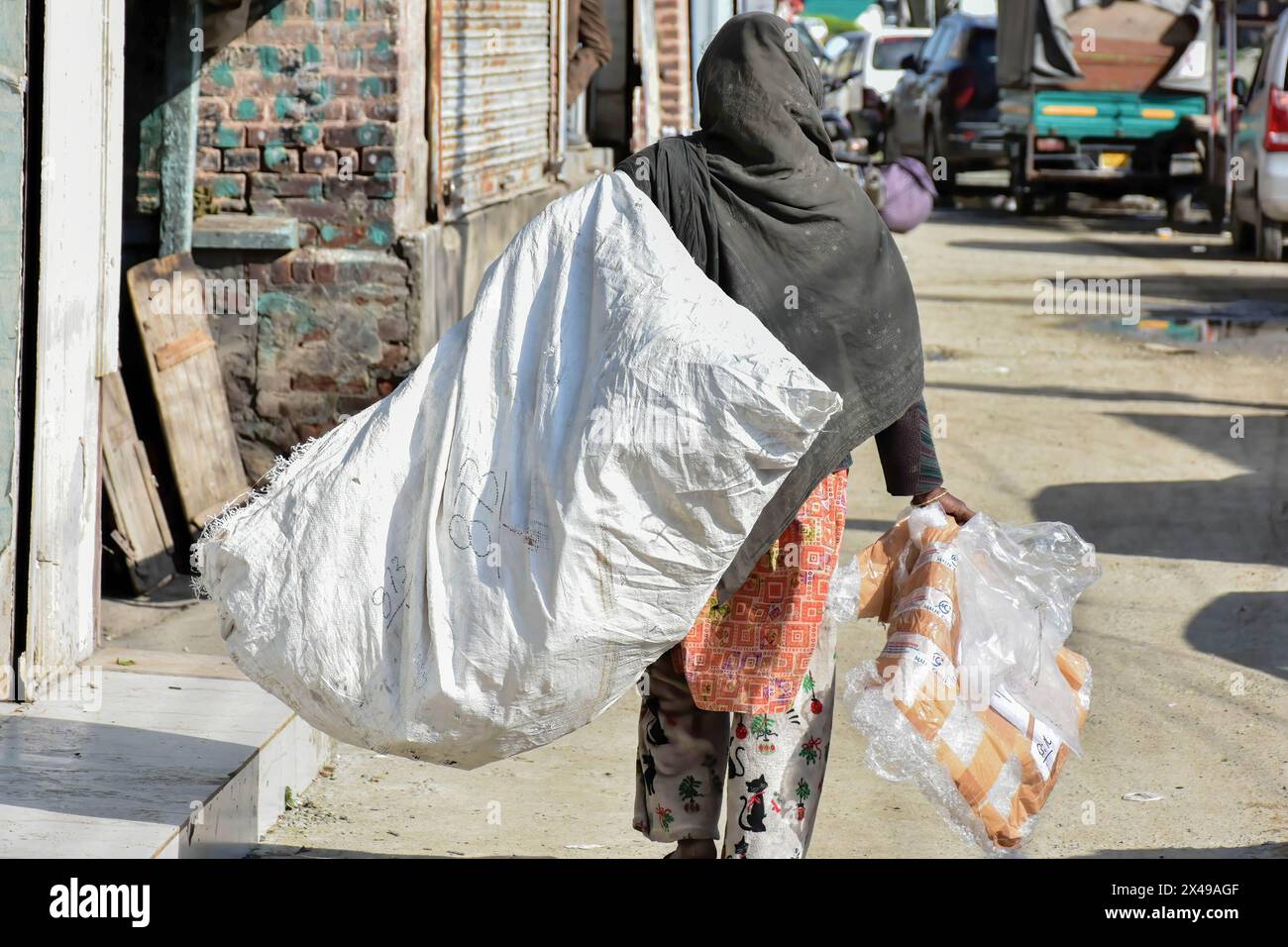 Srinagar, India. 01st May, 2024. A rag picker looks for recyclable ...