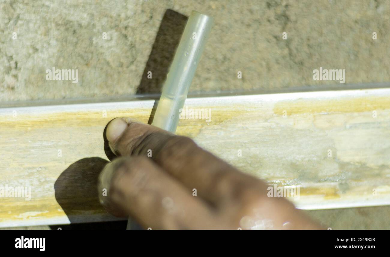 A worker, mason, survayor uses water level to level the height, floor ...