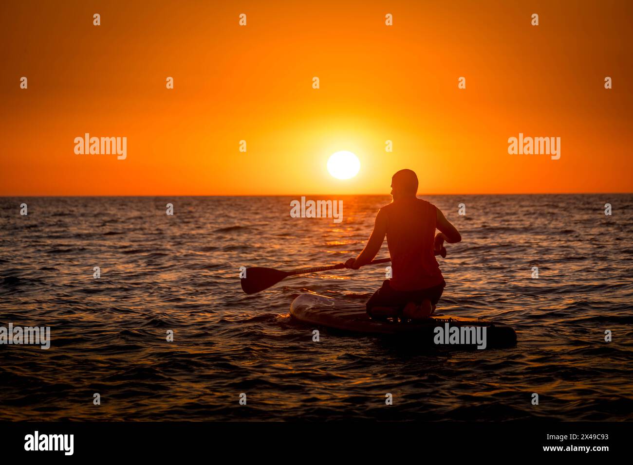 The person on the puddle board watching the sunrise on the Caspian sea ...