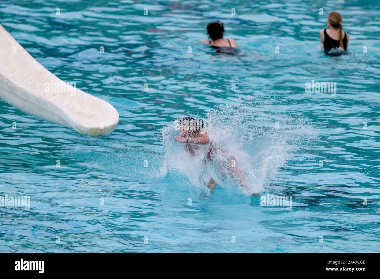 Essen, Germany. 01st May, 2024. A girl slides down a water slide into ...