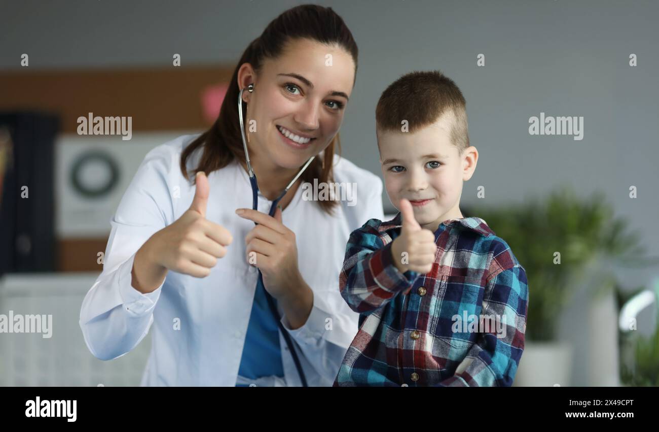 Portrait of smart pediatrician with little patient in clinic office ...
