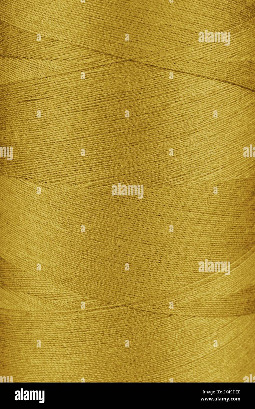 Texture of yellow color threads in spool close up, macro. Sewing threads bobbin abstract ...