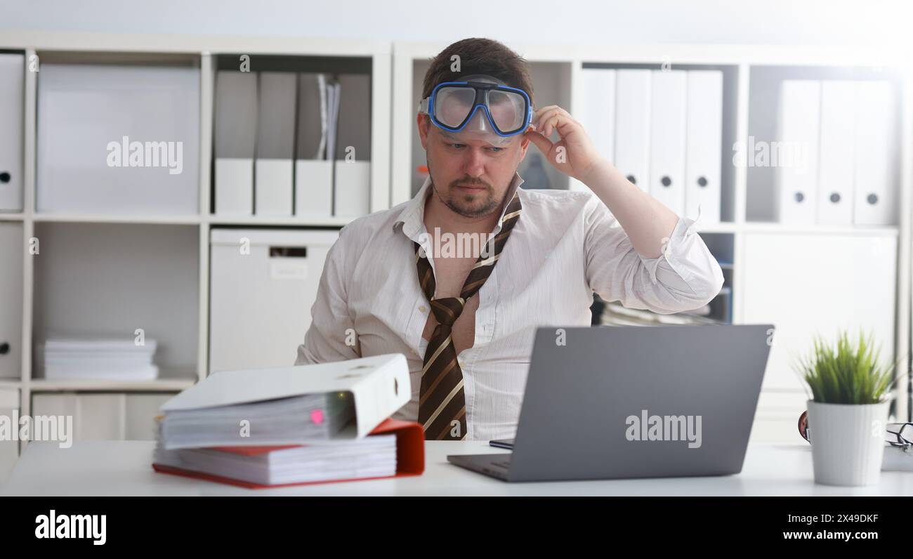 Man wearing suit and tie in goggles with snorkel sit at office ...