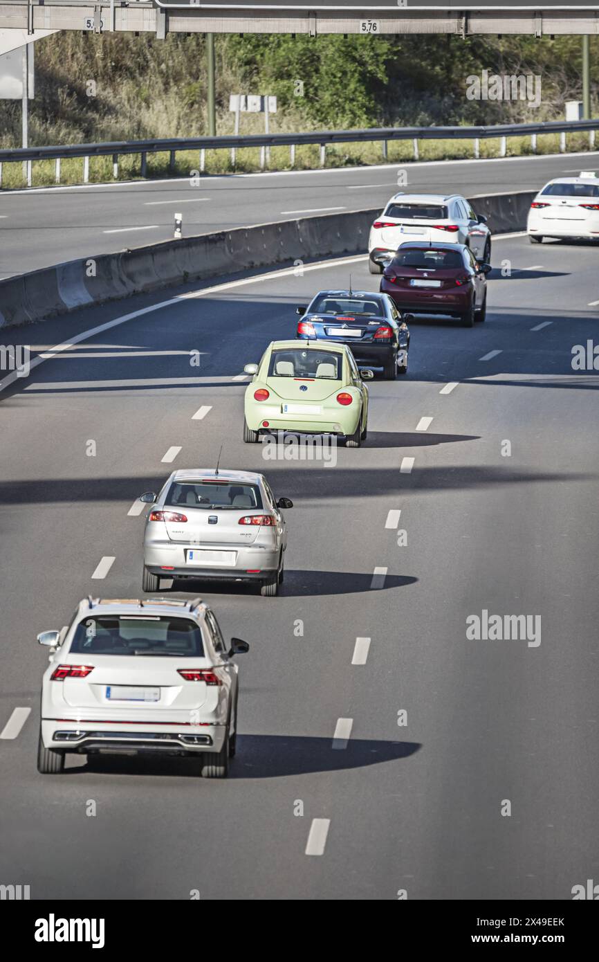 a line of utility vehicles traveling on a highway with several lanes in ...