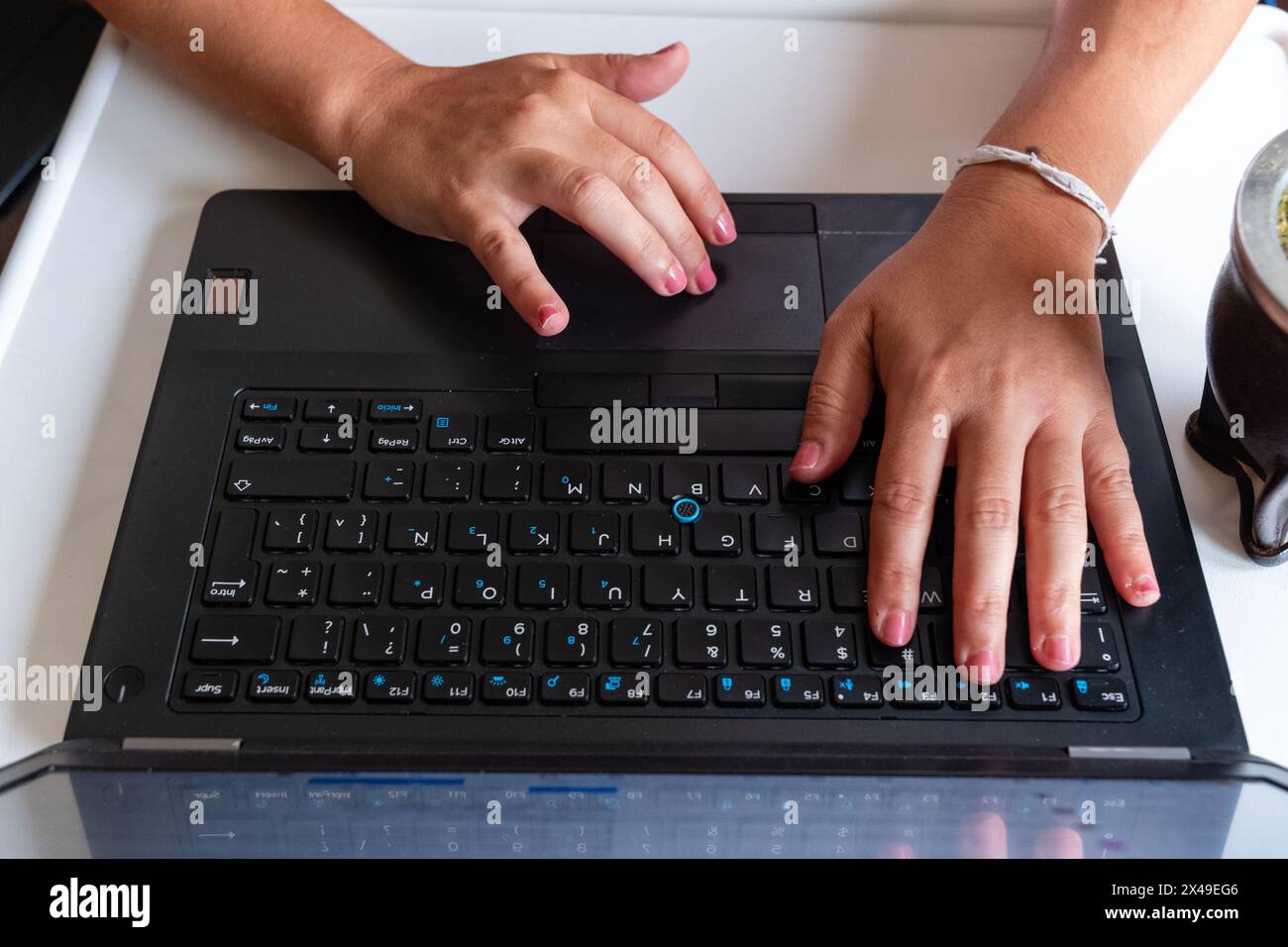 A person is typing on a laptop keyboard. The laptop is open and the ...
