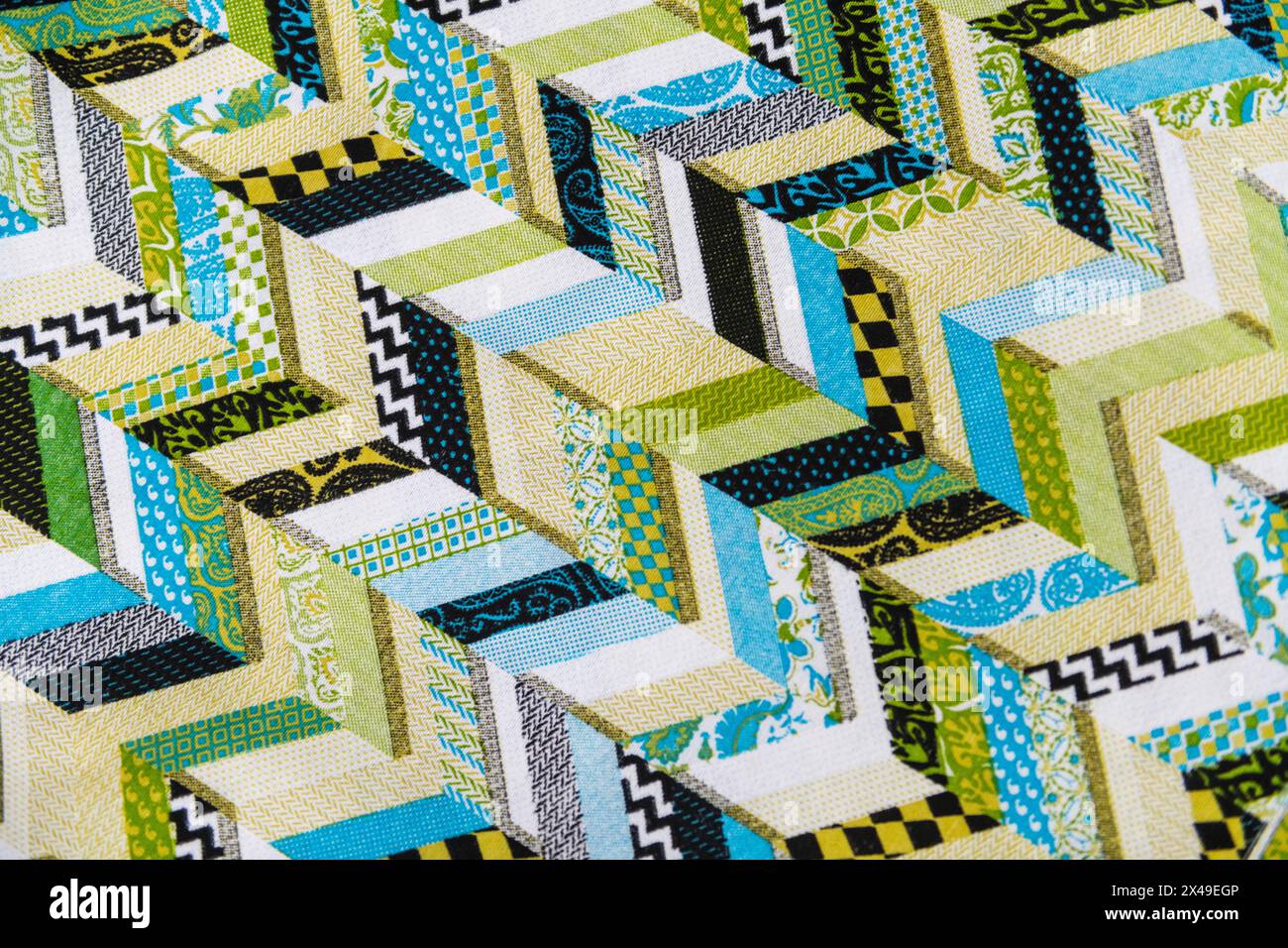 A quilt with a green and white pattern of chevrons. The quilt is made ...