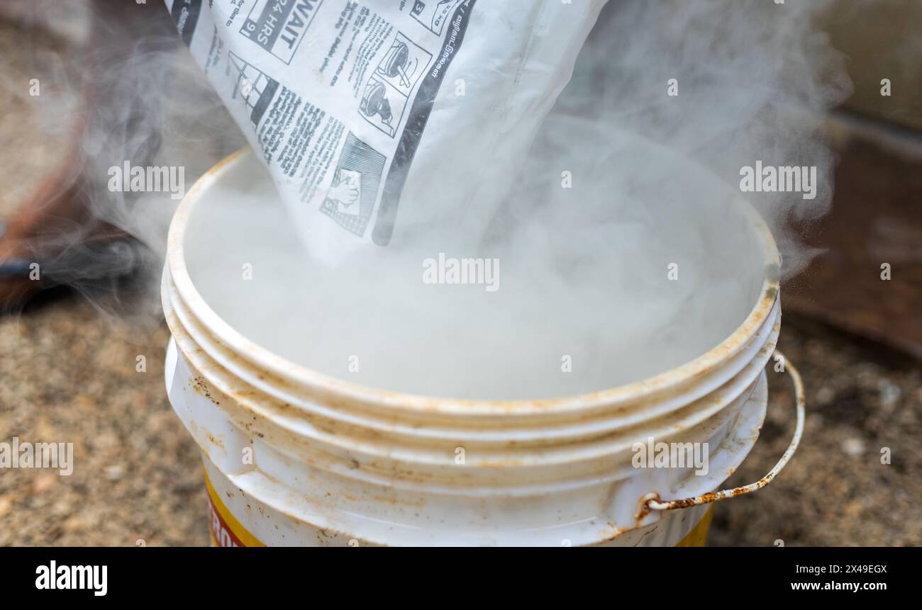 pouring plastering cement to a bucket to mix and make a paste. unsafety ...
