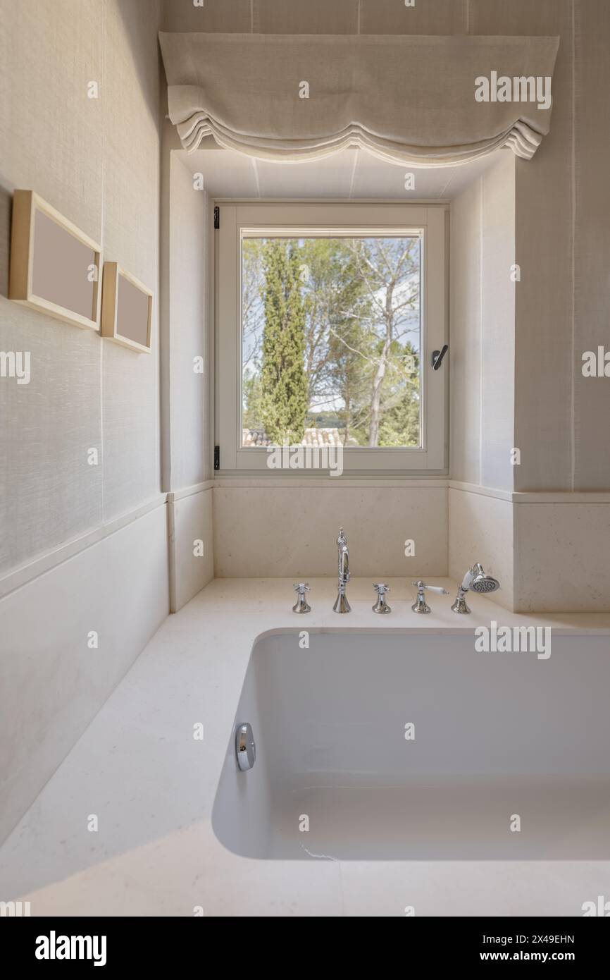 A white porcelain bathtub with marble surrounds with vintage-style ...