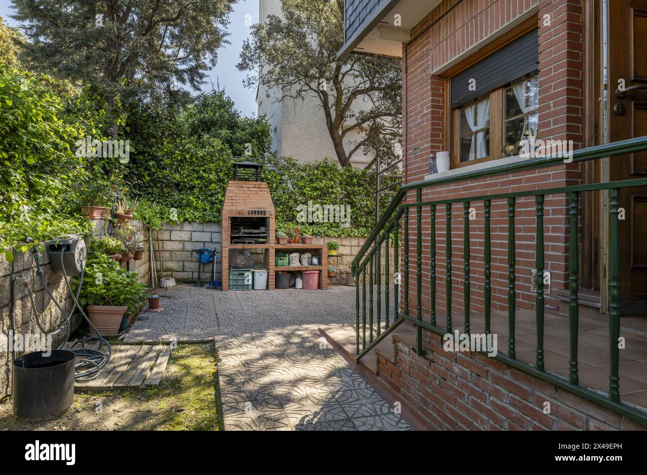 Perimeter garden with tiled path around a single-family house with ...