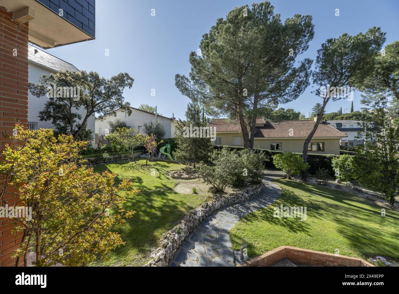 garden with a tiled path and a grassy garden in the background with a ...