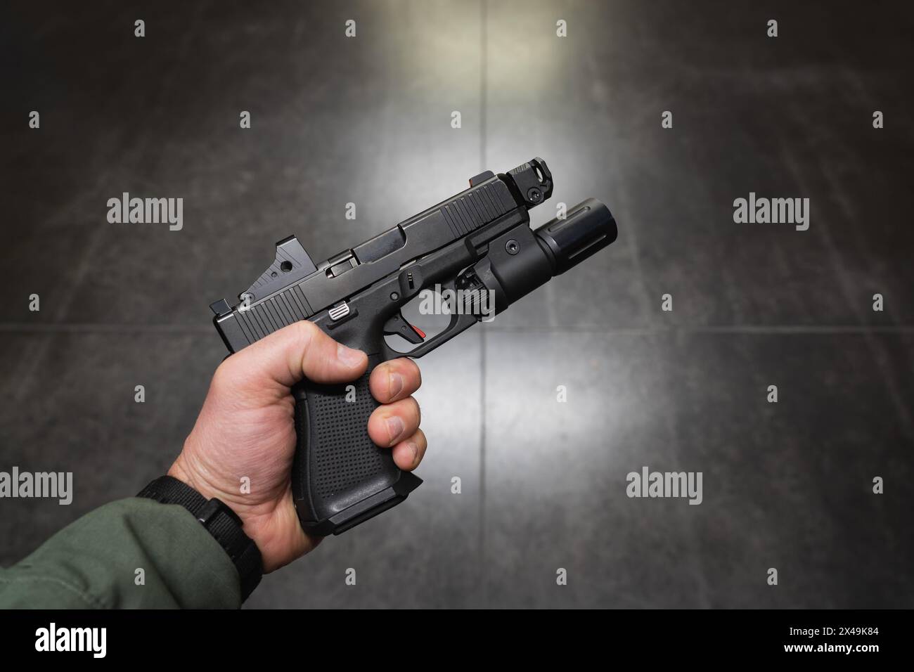 A tactical pistol with an under-barrel flashlight and a modern sight in ...