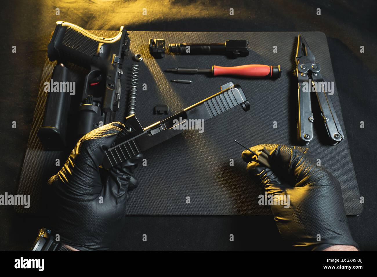 Cleaning and repairing weapons. Hands of a gunsmith and a disassembled ...