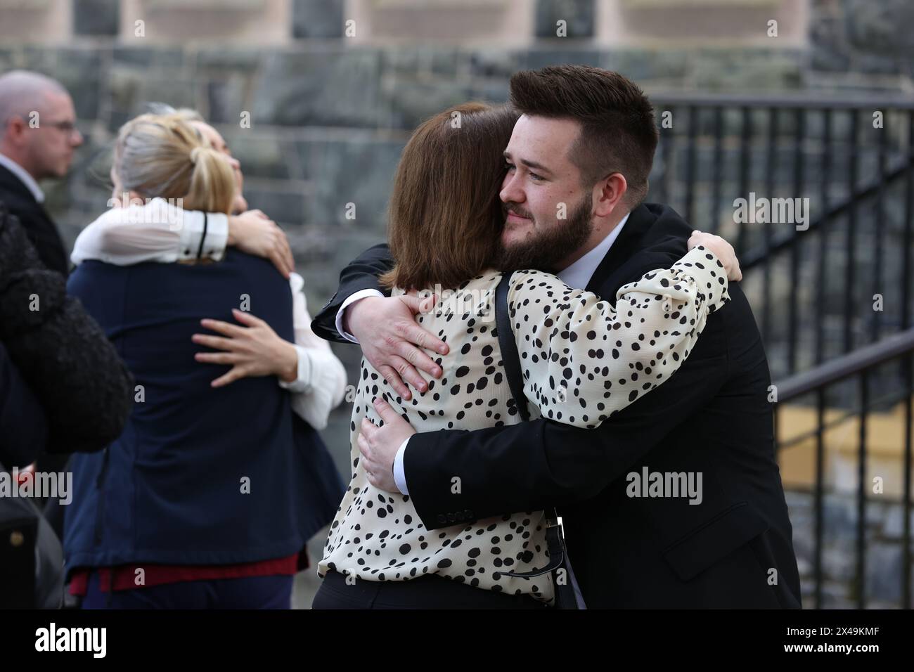 Mourners embrace each other as the hearse, carrying the coffin of ...