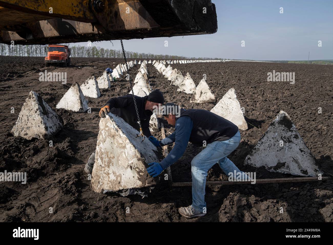 Workers install ani-tank systems known as “dragon teeth” during ...