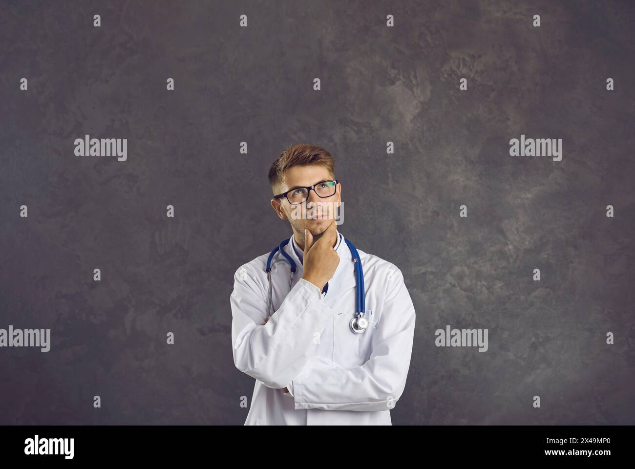 Serious male doctor think of good medical service Stock Photo - Alamy