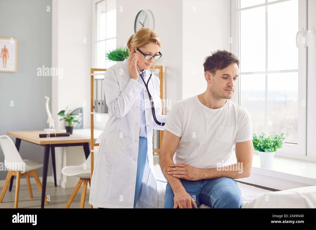 Healthcare professional conducting physical examination on male patient ...