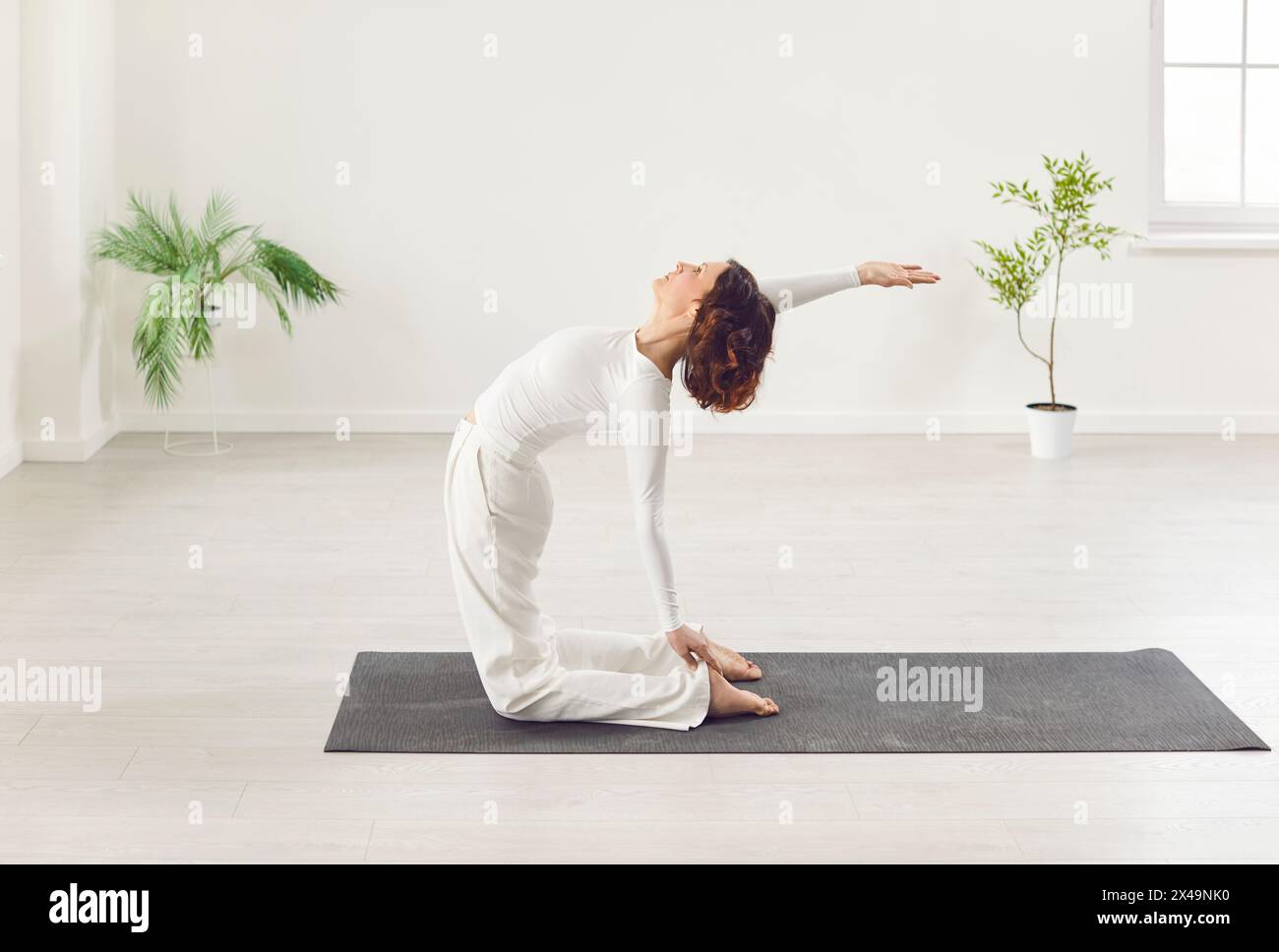Sporty slim woman practicing yoga, stretching in Camel exercise ...