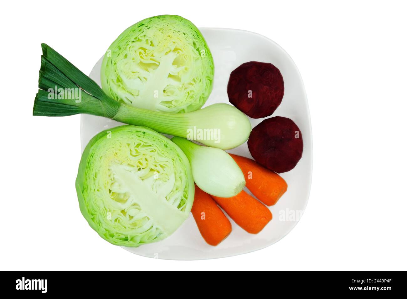 Cabbage, carrots, beets and onions in a plate isolated on white ...