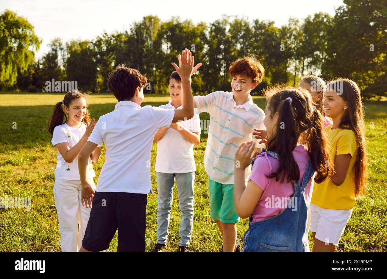 Group of happy kids having fun giving each other high five walking in ...