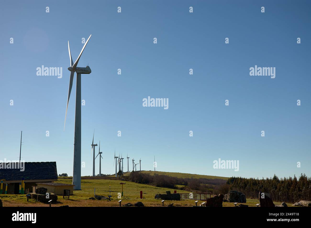 Wind turbines in a beautiful sunny mountain landscape. Curved path through the mountain Wind ...