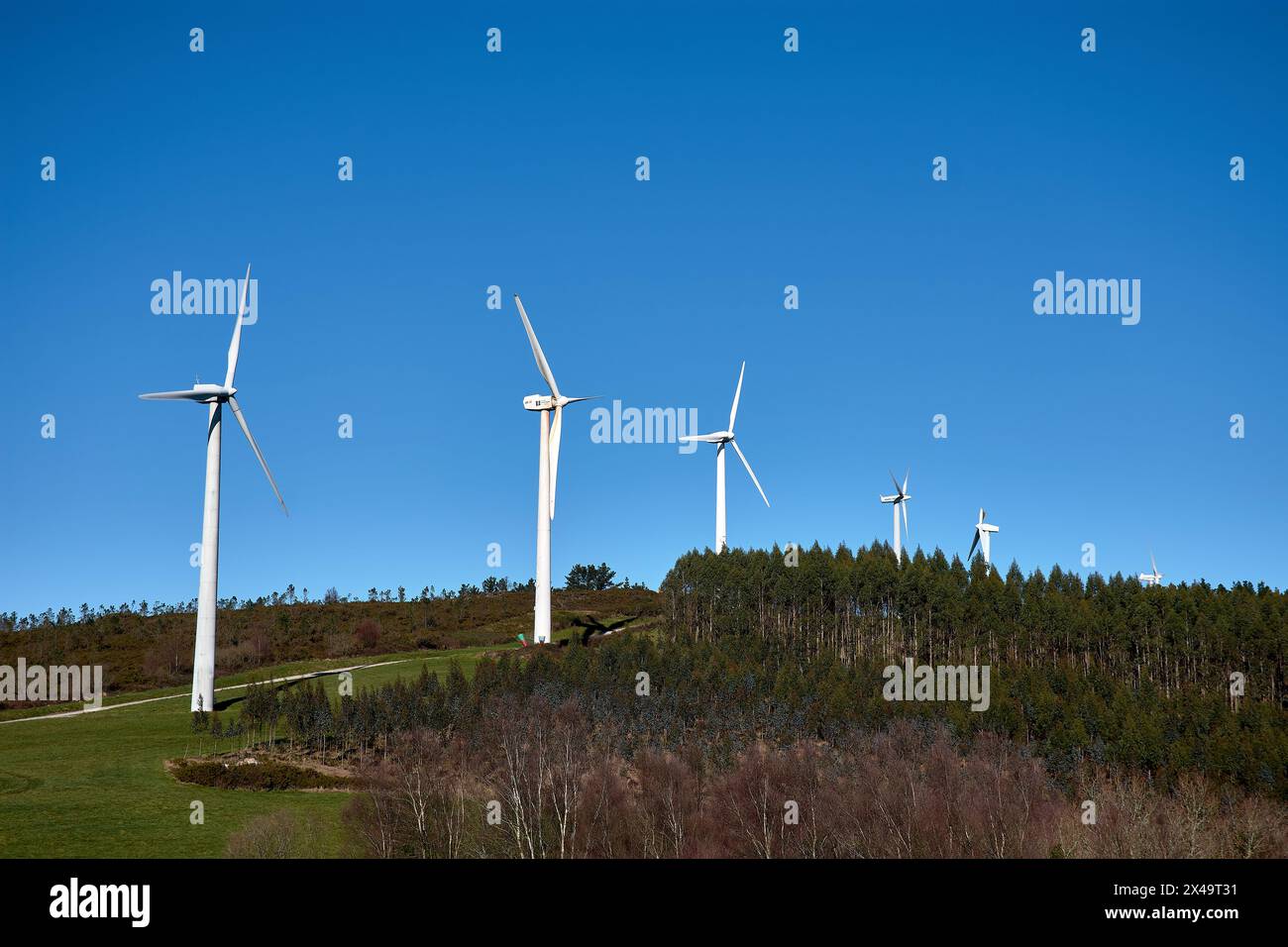 Wind turbines in a beautiful sunny mountain landscape. Curved path ...