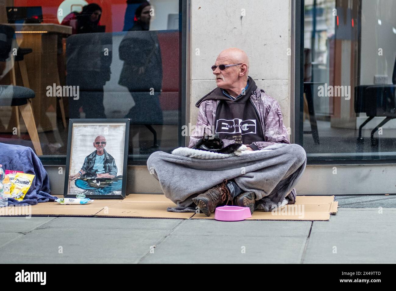 LONDON- APRIL 4th, 2024: A homeless man with a cat on Oxford Street in ...