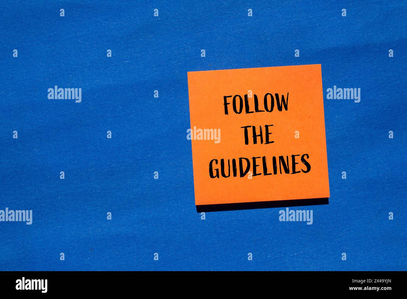 Follow the guidelines words written on orange paper sticker with blue ... Follow the guidelines words written on orange paper sticker with blue ...