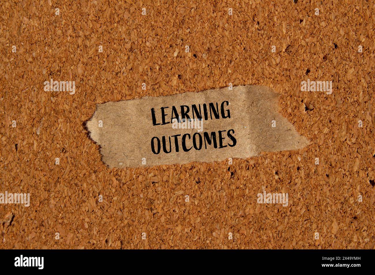 Learning outcomes words written on ripped paper piece with brown background. Conceptual learning ...