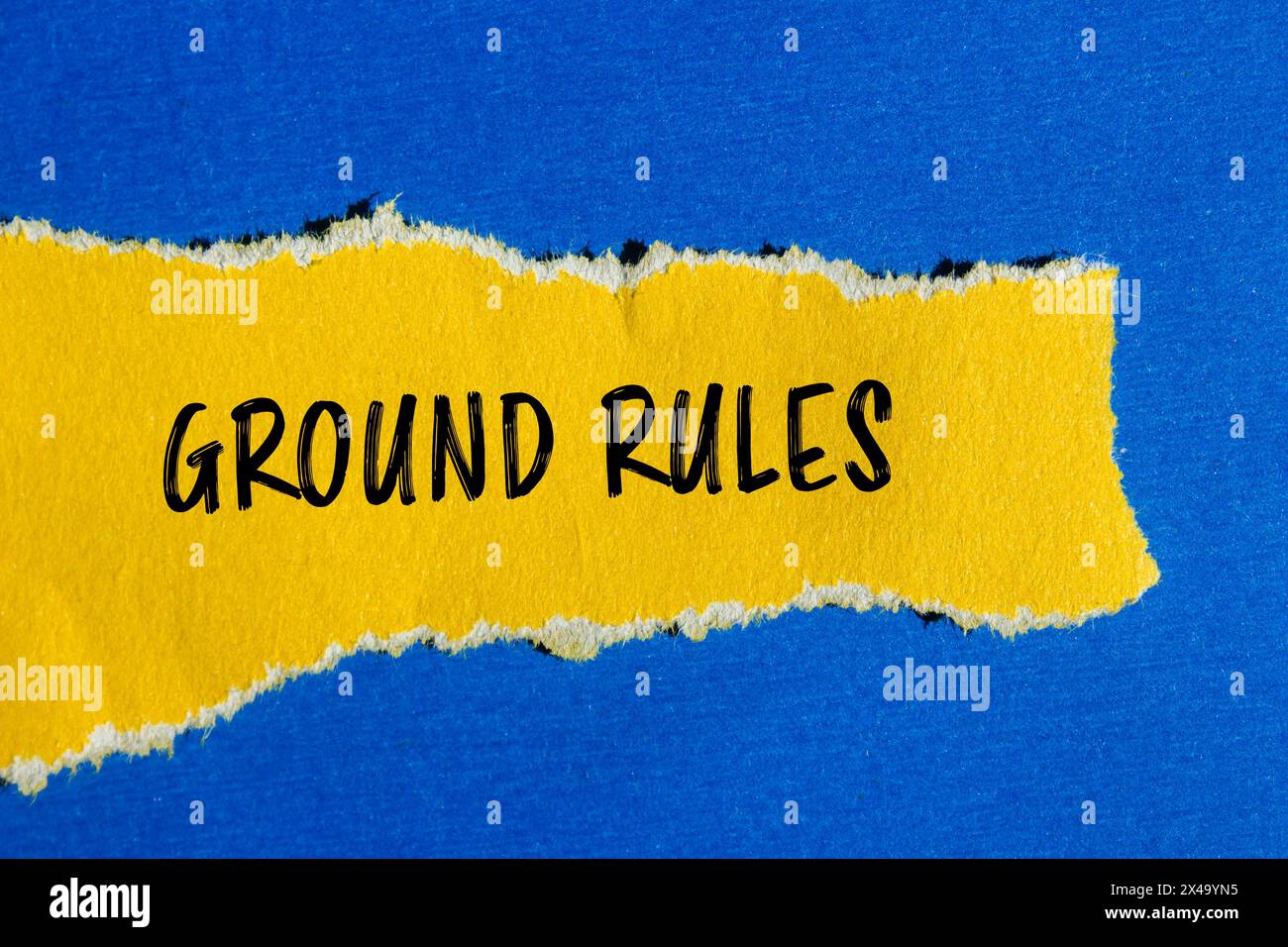 Ground rules words written on ripped yellow paper with blue background ...