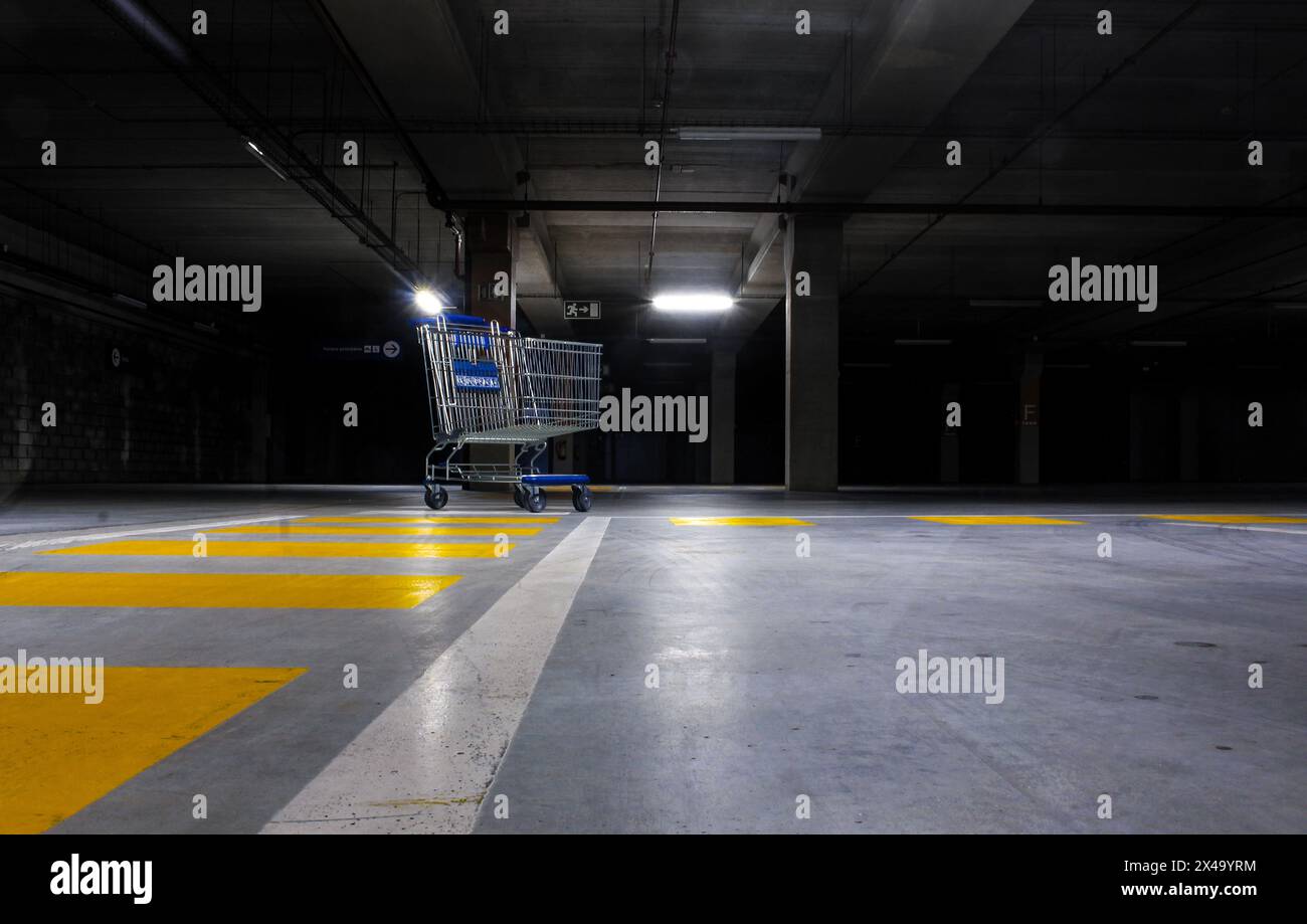 Metallic supermarket shopping cart in underground parking lot. Concept ...