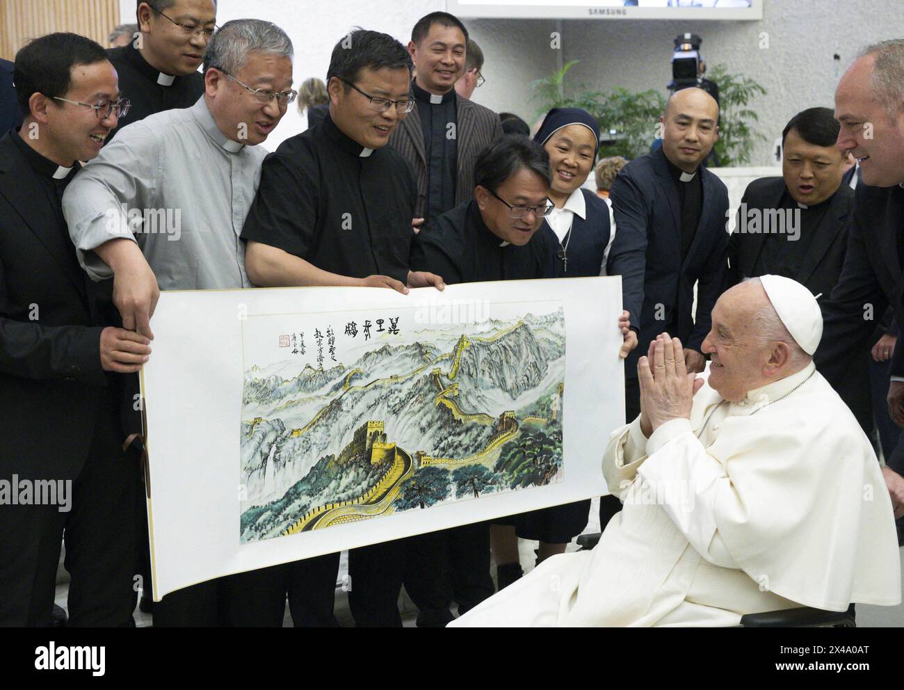 Pope Francis greets a group of Chinese priests showing a painting of ...