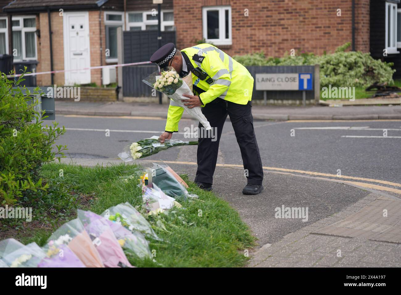 A police officer laid flowers on the corner of Laing Close in Hainault ...