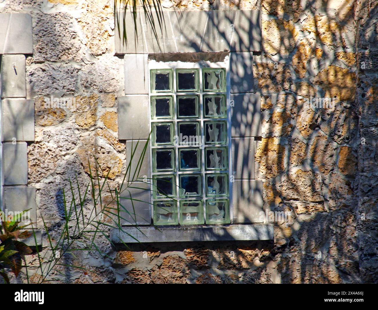 Window with glass squares on wall of coral. Traditional architecture ...