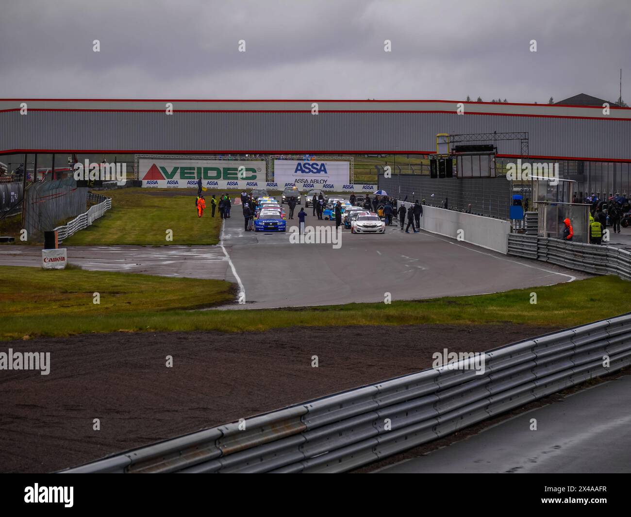 Race cars and race officials and mechanics on the Anderstorp race track ...
