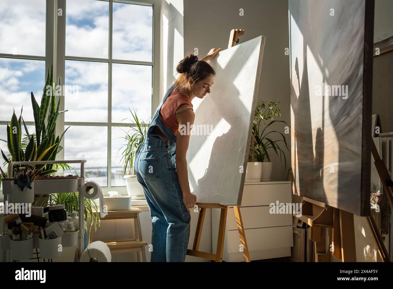 Female professional artist art workshop makes preparation canvas ...