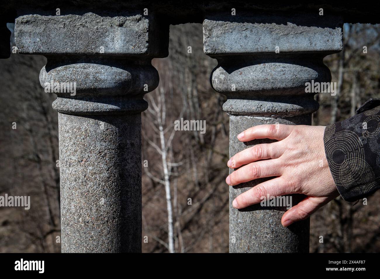 Hand on stone pillar, exploring the constructs of architectural element ...