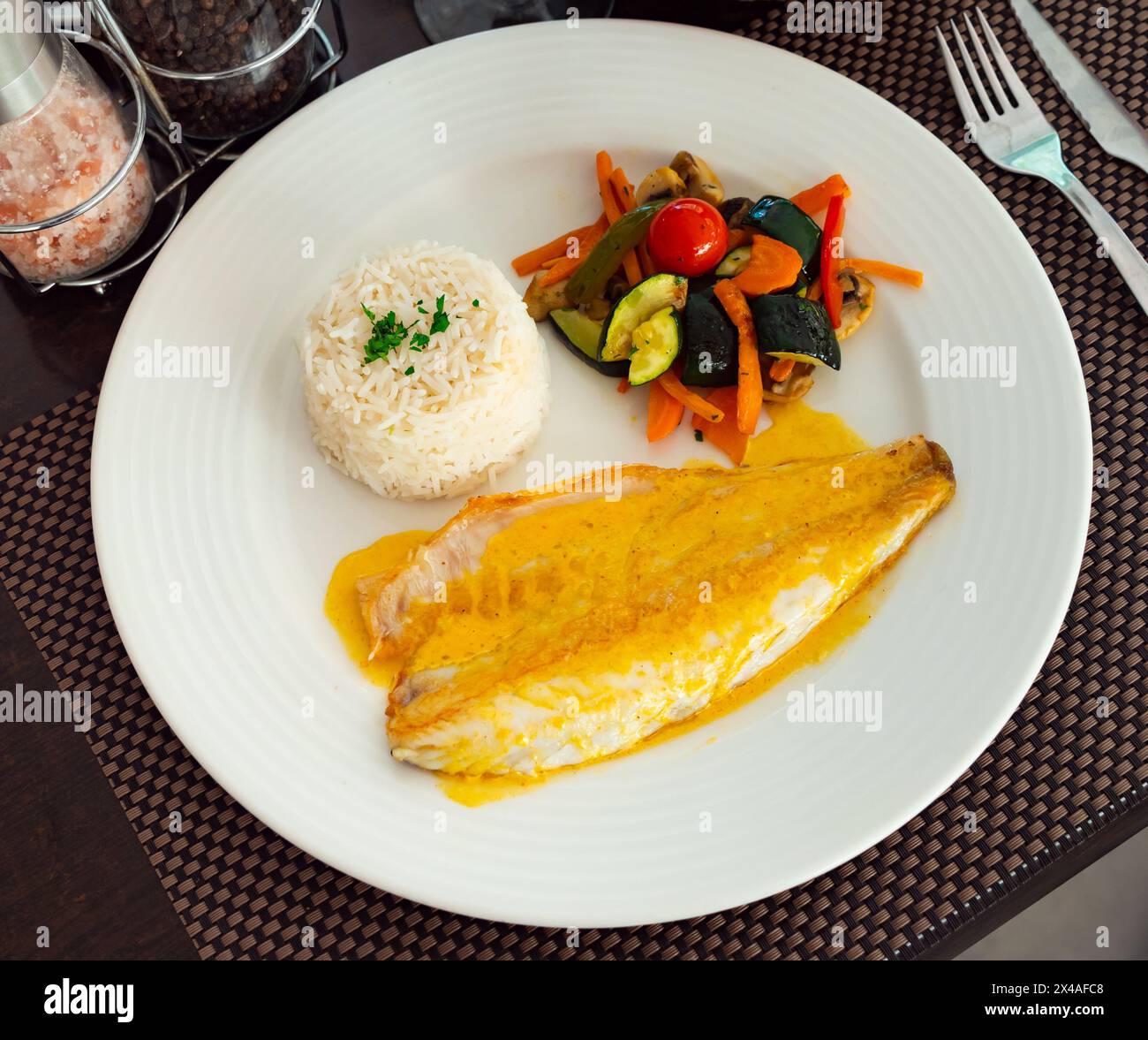 Sea bass with curry, vegetables and rice Stock Photo - Alamy