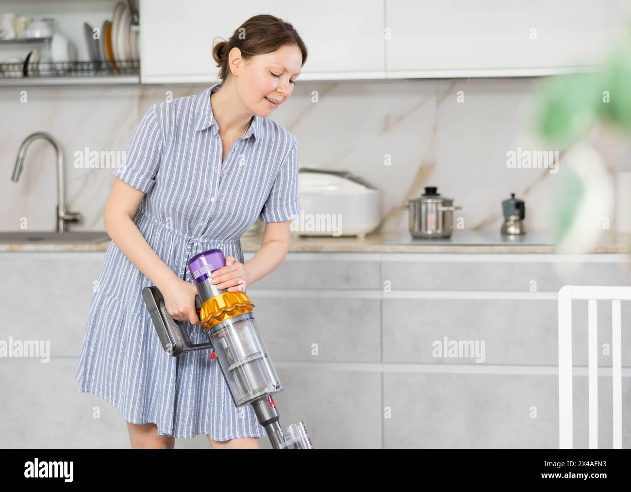 Housewife using vacuum cleaner removes dust in room Stock Photo - Alamy