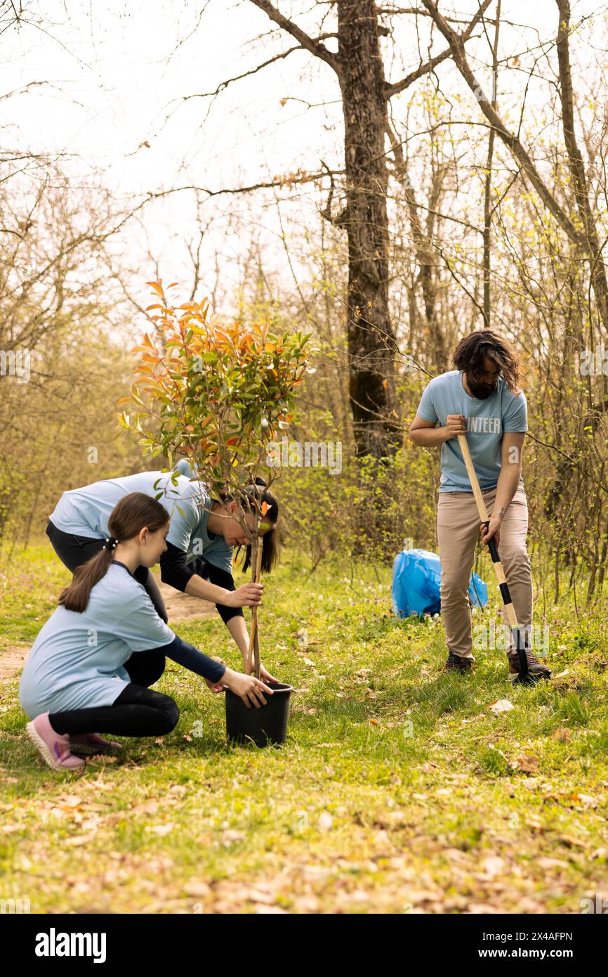 Group of activists planting small trees for nature preservation ...